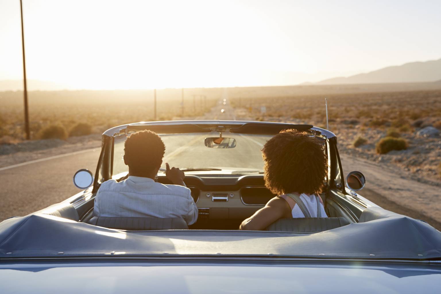 Rear View Of Couple On Road Trip Driving Classic Convertible Car ...
